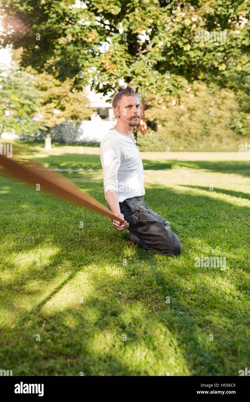portrait of man sitting on slackline and balancing on a rope Stock ...