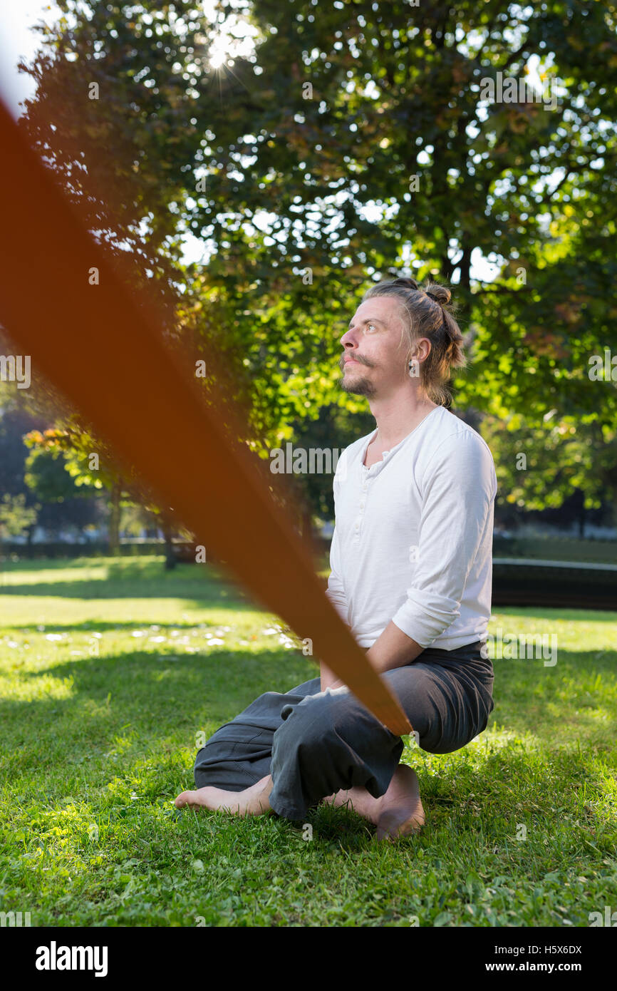 portrait of man sitting on slackline and balancing on a rope Stock ...