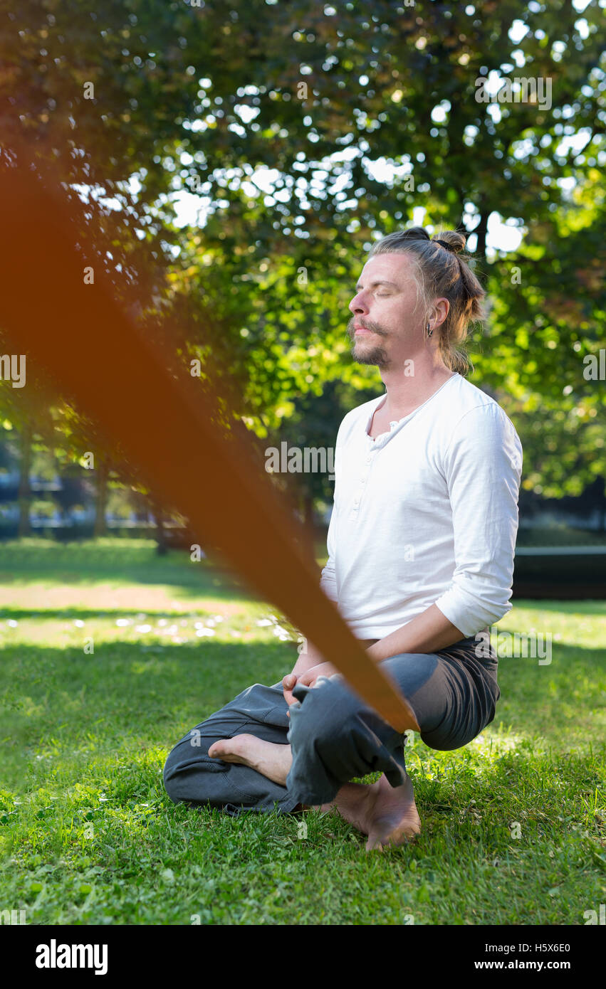portrait of man sitting on slackline and balancing on a rope Stock ...