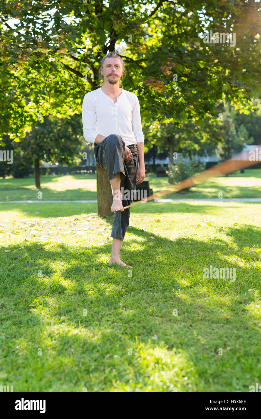Guy practising slack line in the city park Stock Photo - Alamy