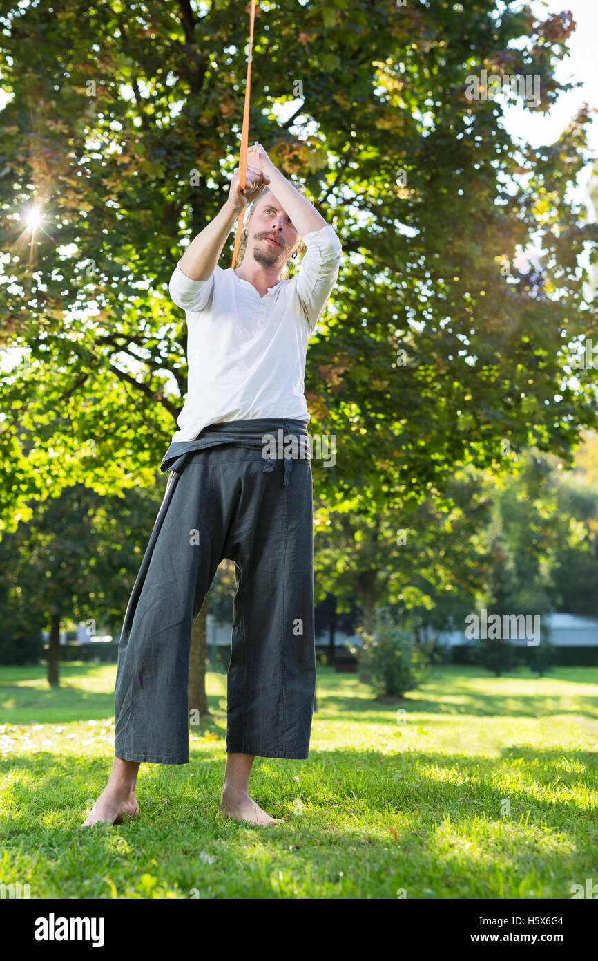 Guy practising slack line in the city park Stock Photo - Alamy