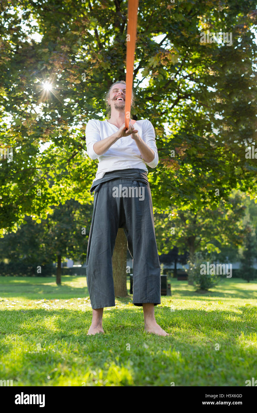 Guy practising slack line in the city park Stock Photo - Alamy