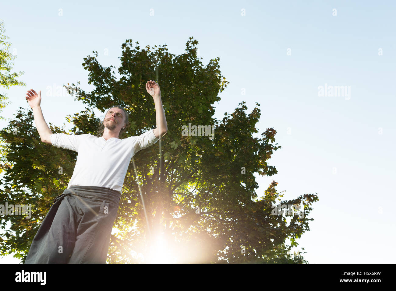 Young man feeling free under a perfect blue sky Stock Photo - Alamy
