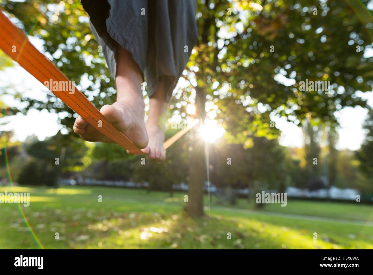 Closeup mans feet from behind balancing on slackline Stock Photo - Alamy