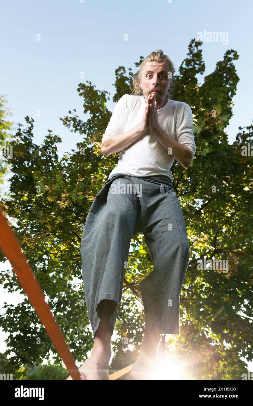 Guy practising slack line in the city park Stock Photo - Alamy