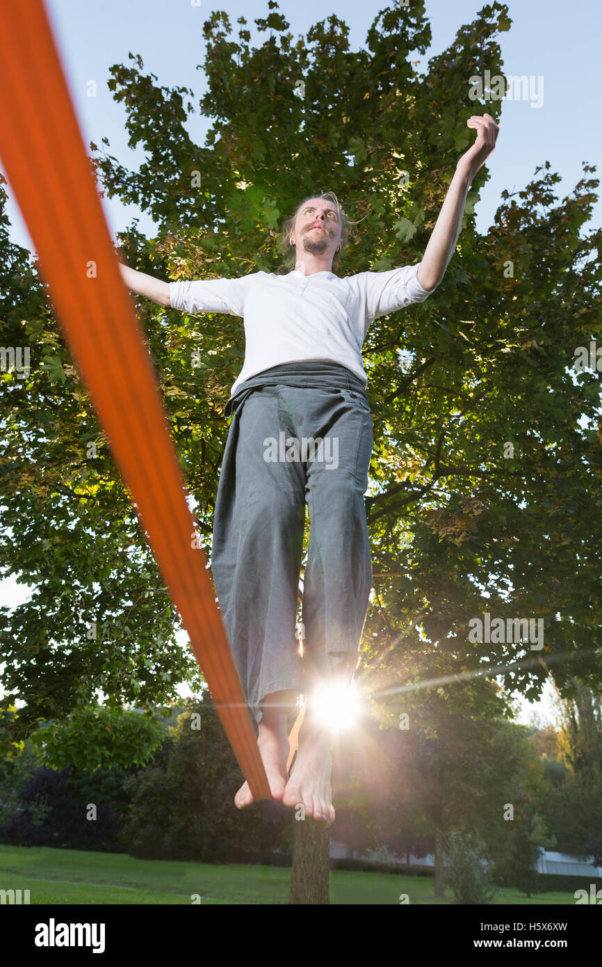 Portrait of man on slackline. Slacklining is a practice in balance ...