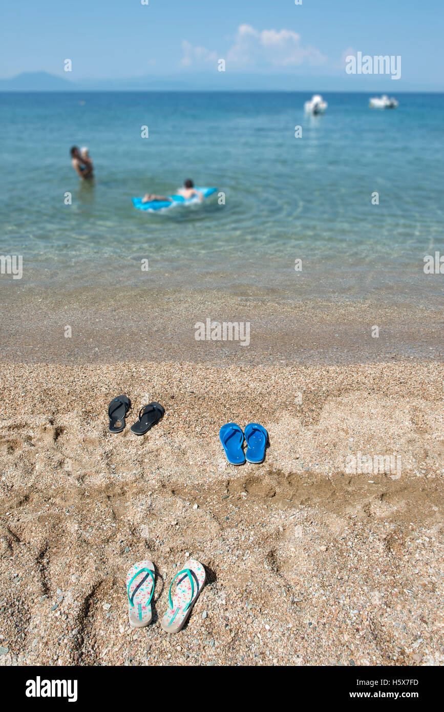Slippers in the sand on the beach and people at sea Stock Photo - Alamy