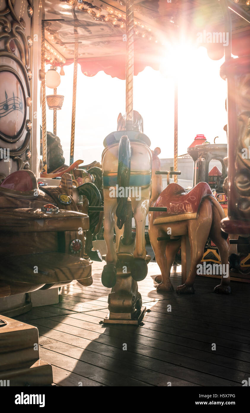 Carousel with horses in amusement park. Sun backlight Stock Photo - Alamy