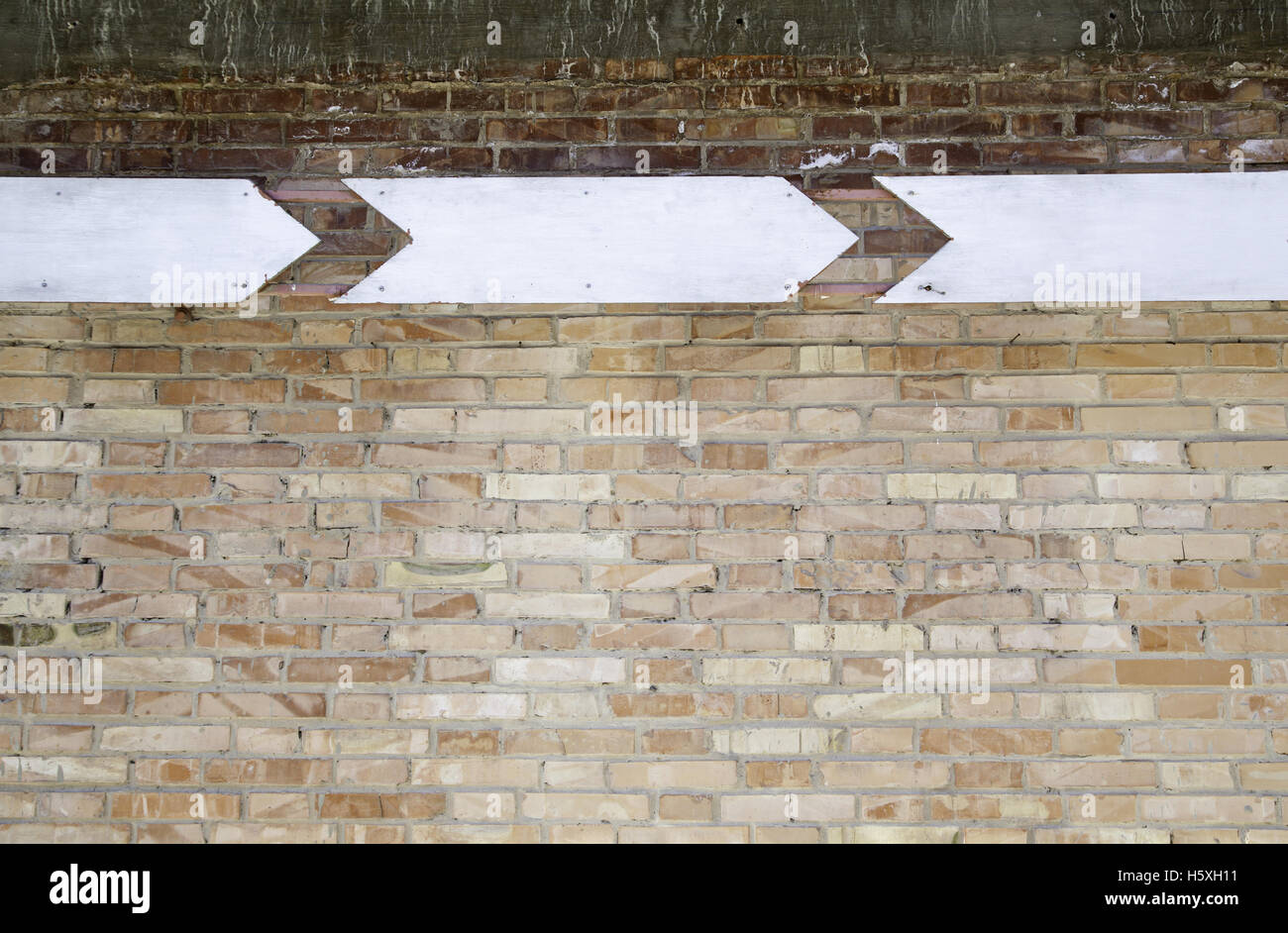 Brick wall with arrows signs, detail of old brick wall with information ...