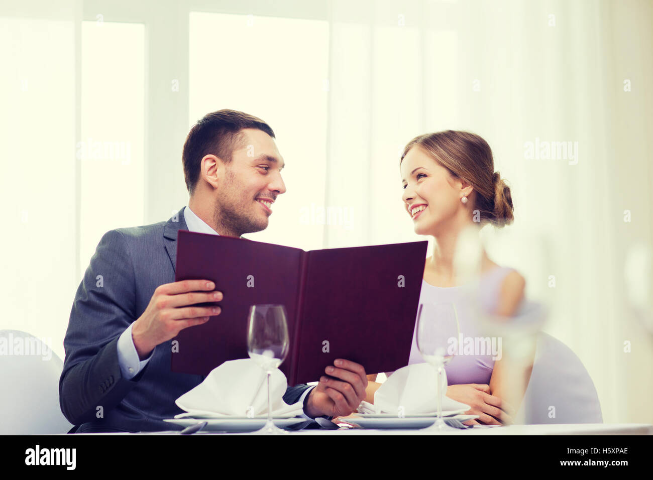 smiling couple with menu at restaurant Stock Photo - Alamy