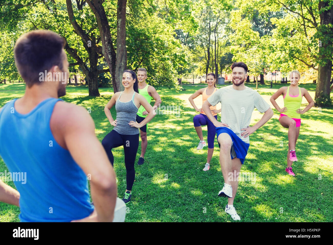 group of friends or sportsmen exercising outdoors Stock Photo - Alamy