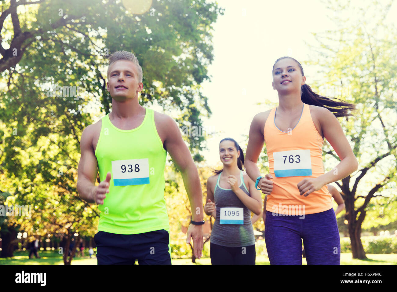 happy young sportsmen racing wit badge numbers Stock Photo - Alamy