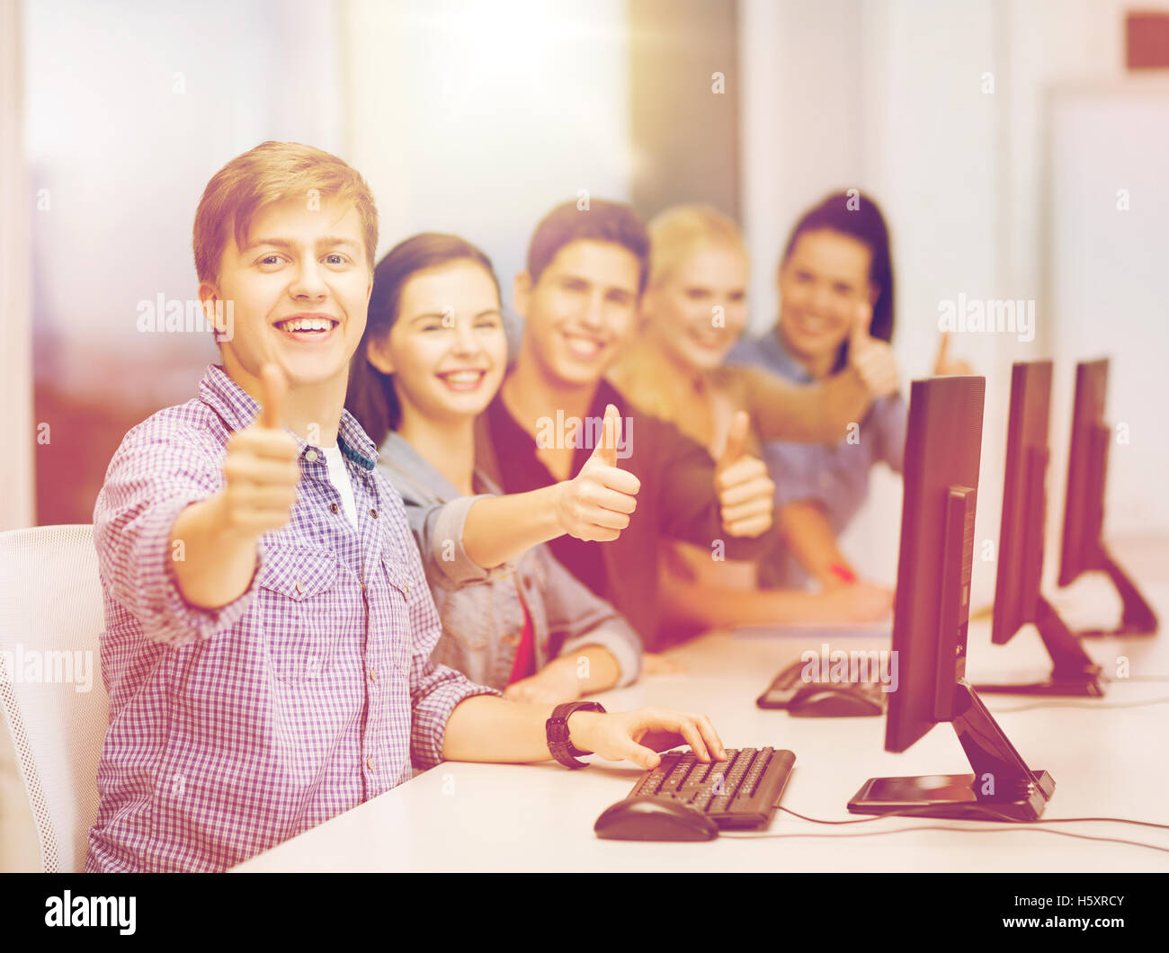 students with computer monitor showing thumbs up Stock Photo - Alamy