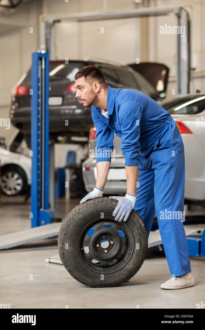mechanic with wheel tire at car workshop Stock Photo - Alamy