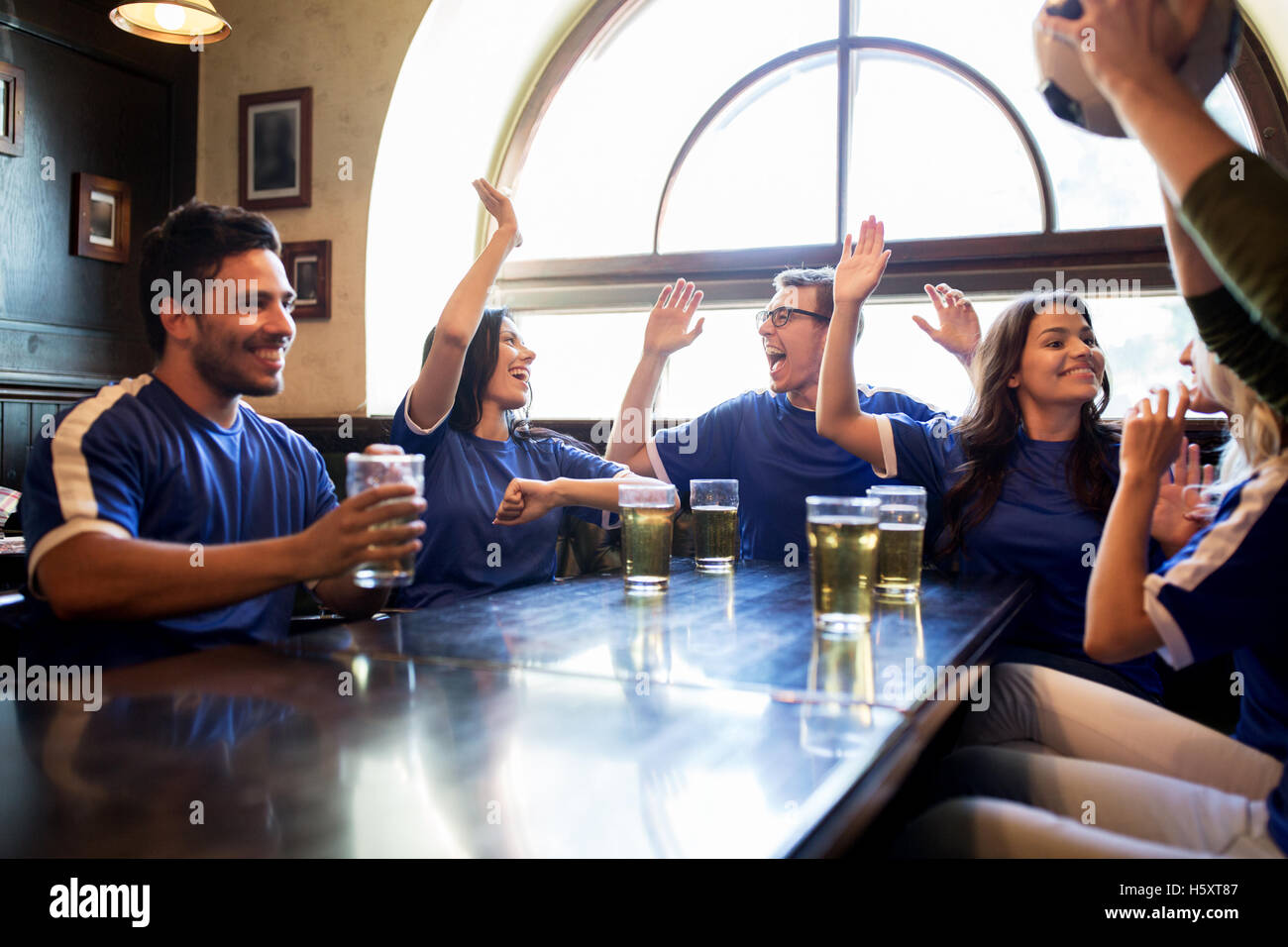 football fans with beer celebrating victory at bar Stock Photo - Alamy