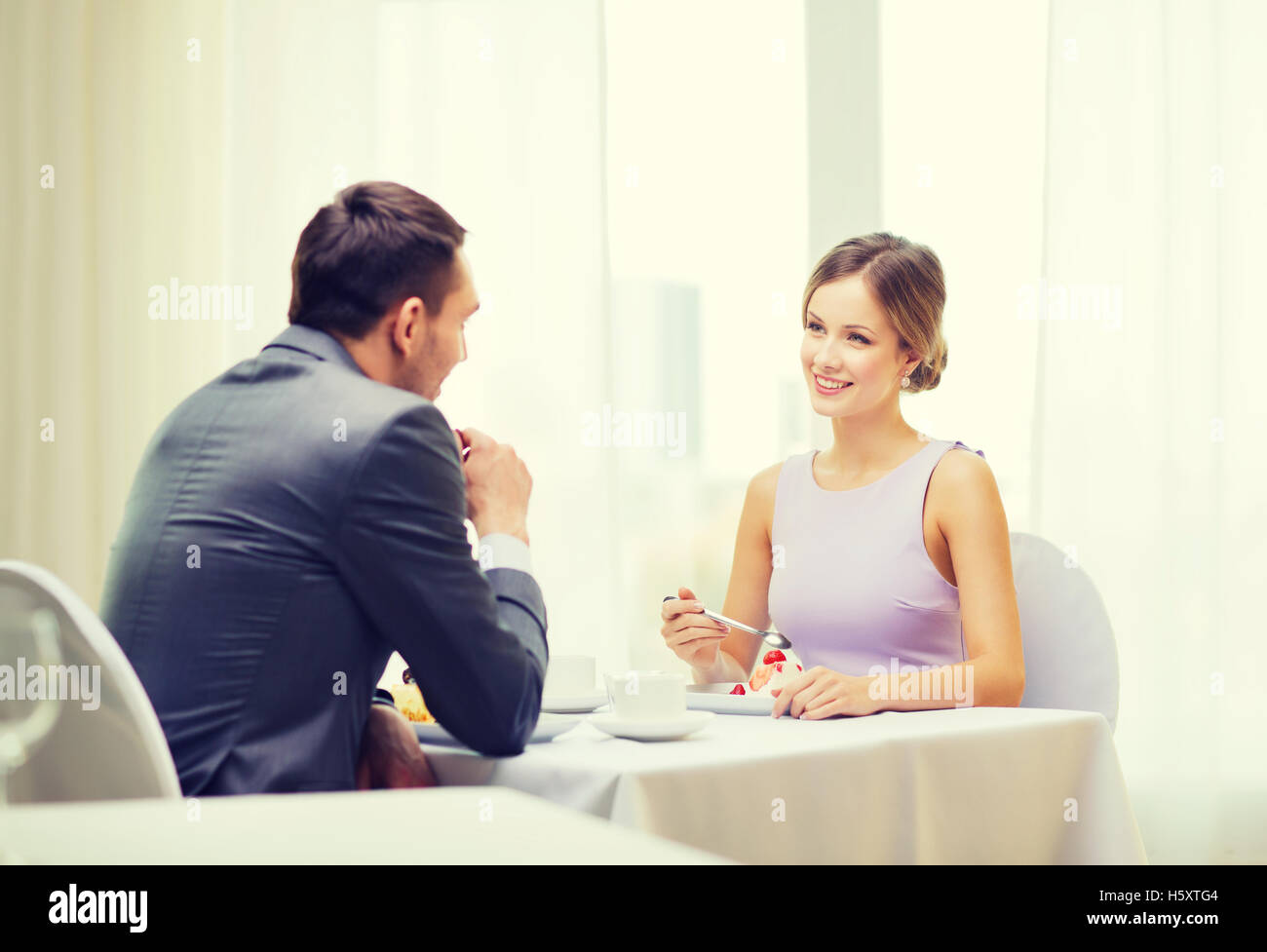 smiling couple eating dessert at restaurant Stock Photo - Alamy