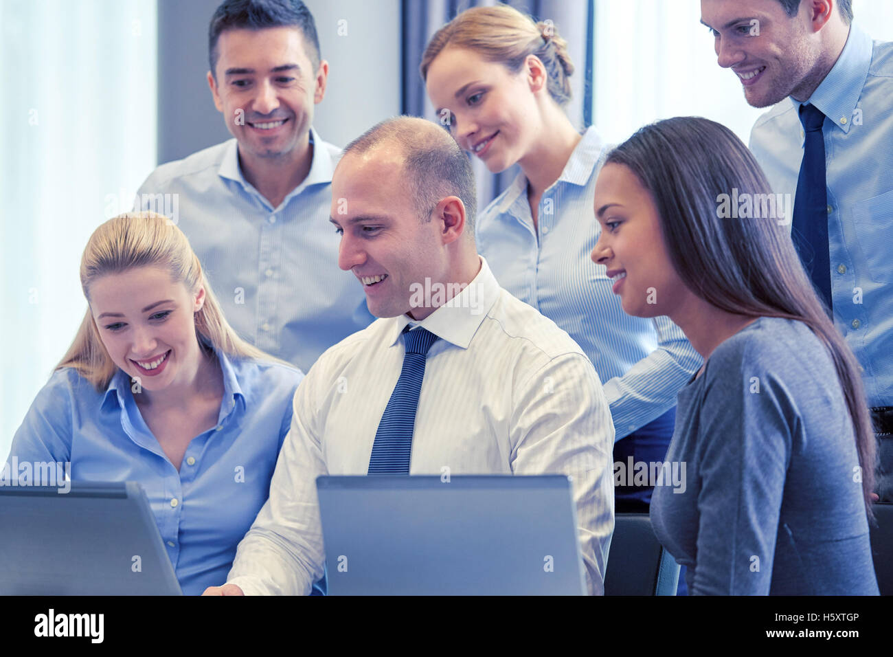 Smiling workers looking laptop hi-res stock photography and images - Alamy