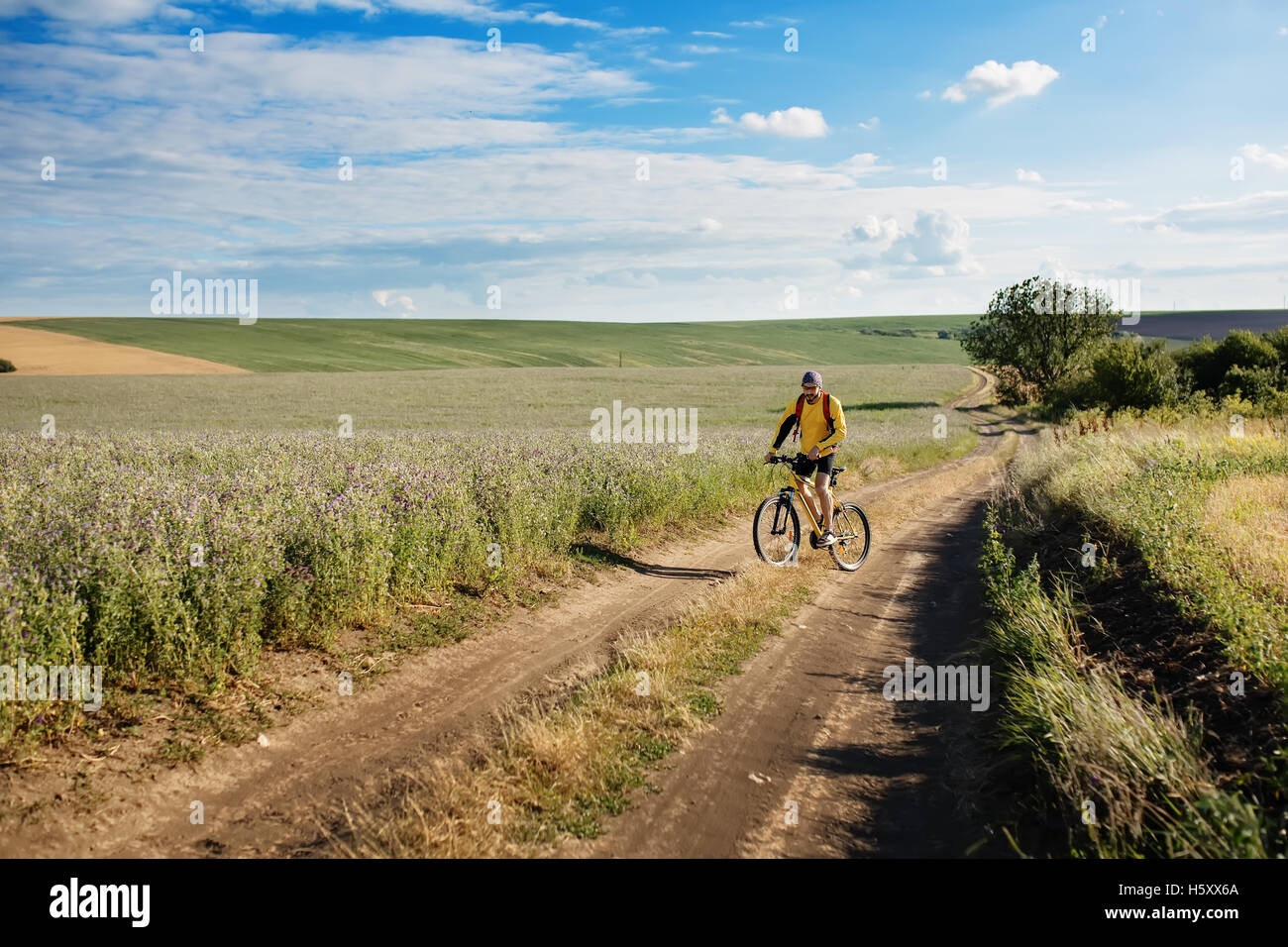 Cyclist riding a bike on an off road to the sunset. Wild landscape ...