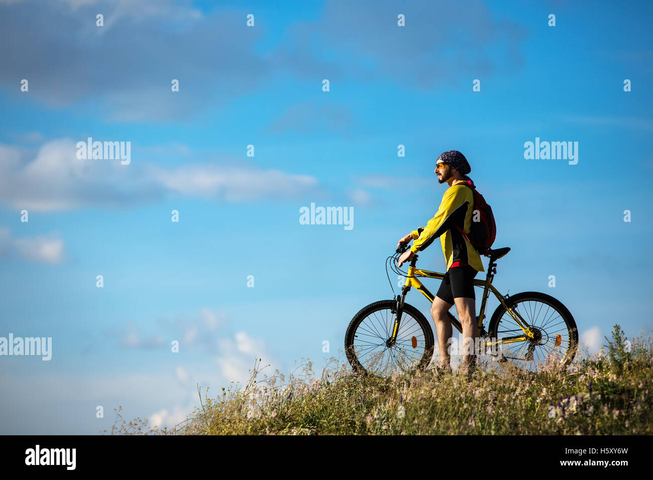 Cyclist riding a bike on an off road to the sunset. Wild landscape ...