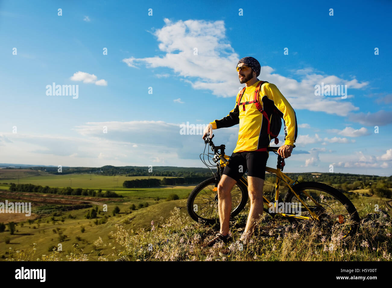 Cyclist riding a bike on an off road to the sunset. Wild landscape ...