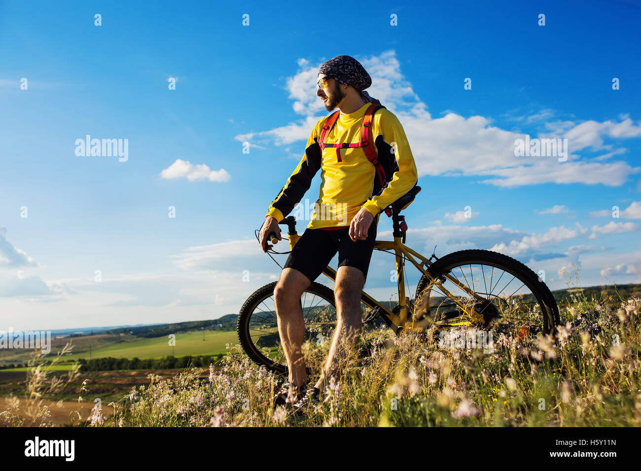 Cyclist riding a bike on an off road to the sunset. Wild landscape ...