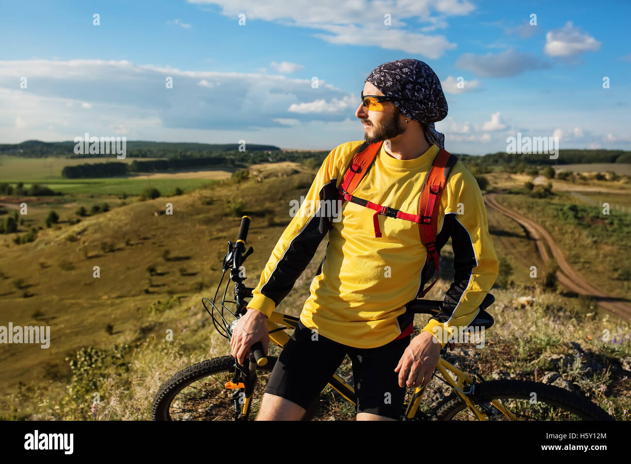 Cyclist riding a bike on an off road to the sunset. Wild landscape ...