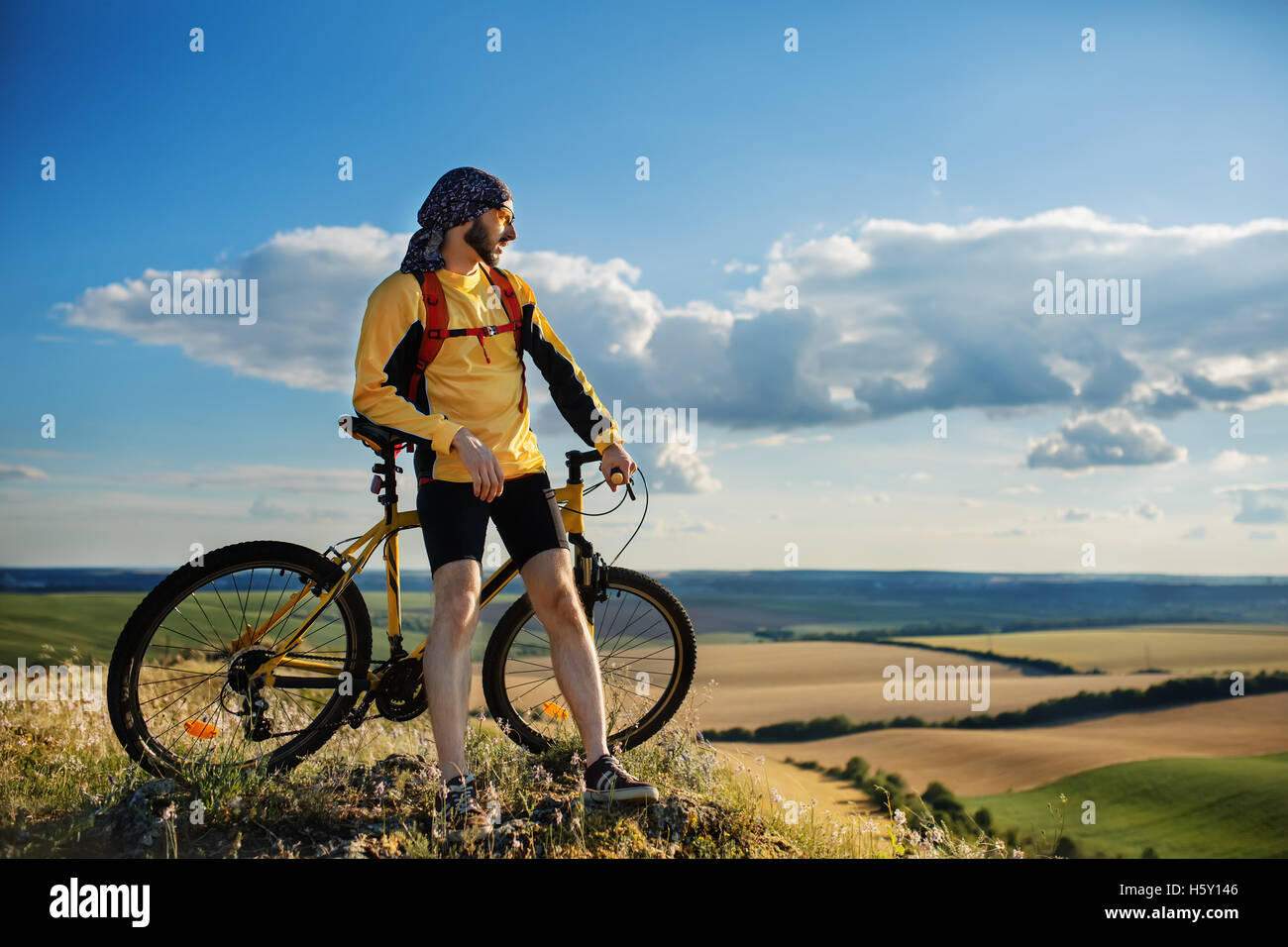 Cyclist riding a bike on an off road to the sunset. Wild landscape ...