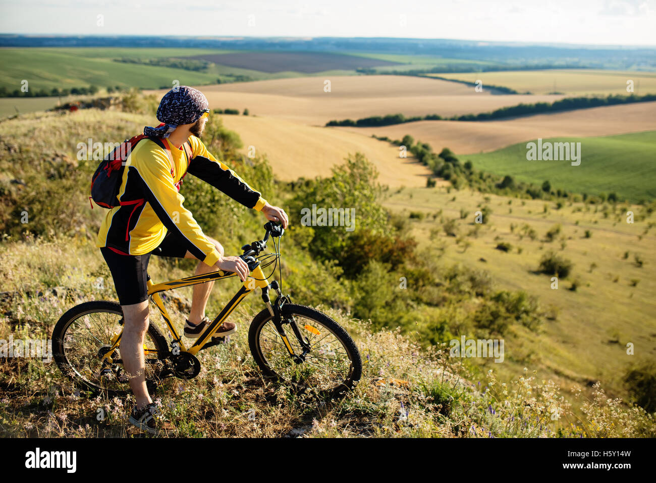 Cyclist riding a bike on an off road to the sunset. Wild landscape ...