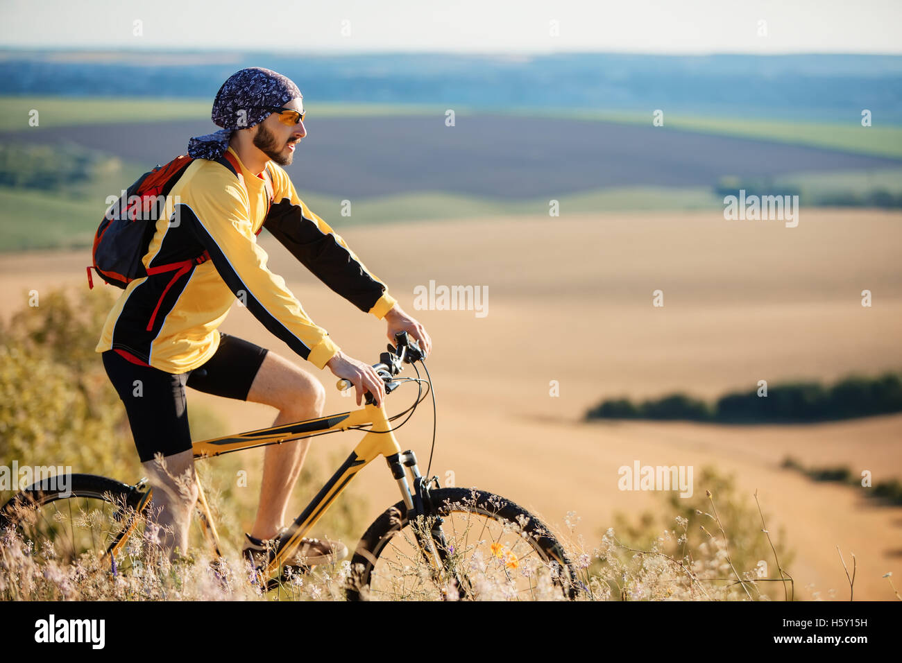 Cyclist riding a bike on an off road to the sunset. Wild landscape ...
