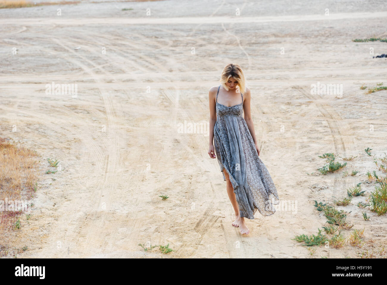 Full length of sad beautiful young woman walking on the road Stock ...