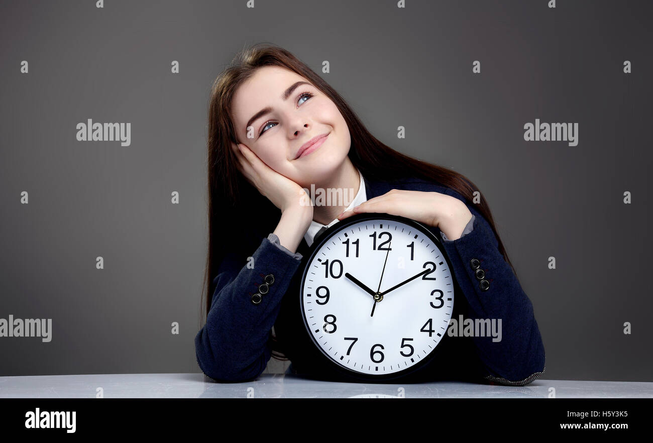 Portrait of beautiful young girl sitting with clock Stock Photo - Alamy