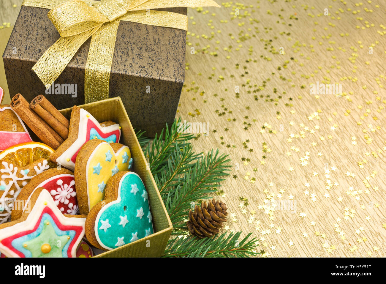 christmas decorations with gift boxes and gingerbread cookies on gold ...