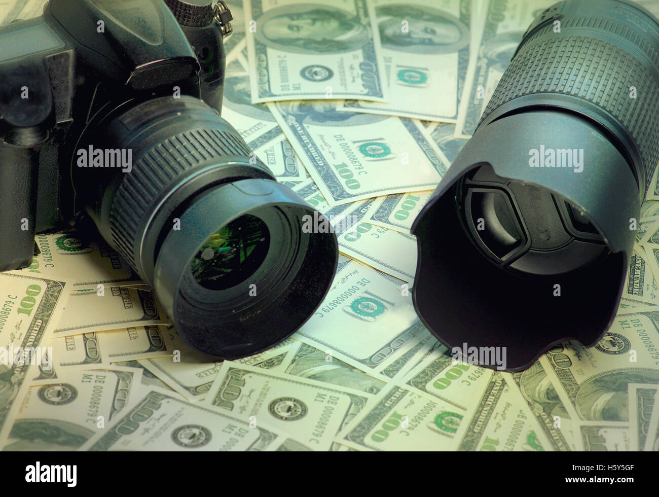 Camera lens on money photo background image Stock Photo - Alamy