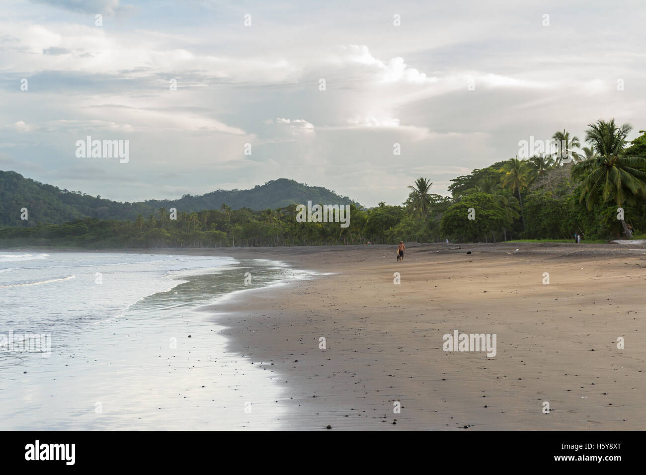 Tambor, Costa Rica - June 20: Young surfer walking the beach with his ...