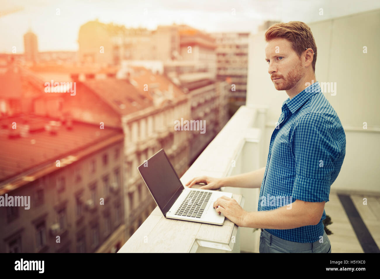 Businessman working on rooftop terrace Stock Photo - Alamy