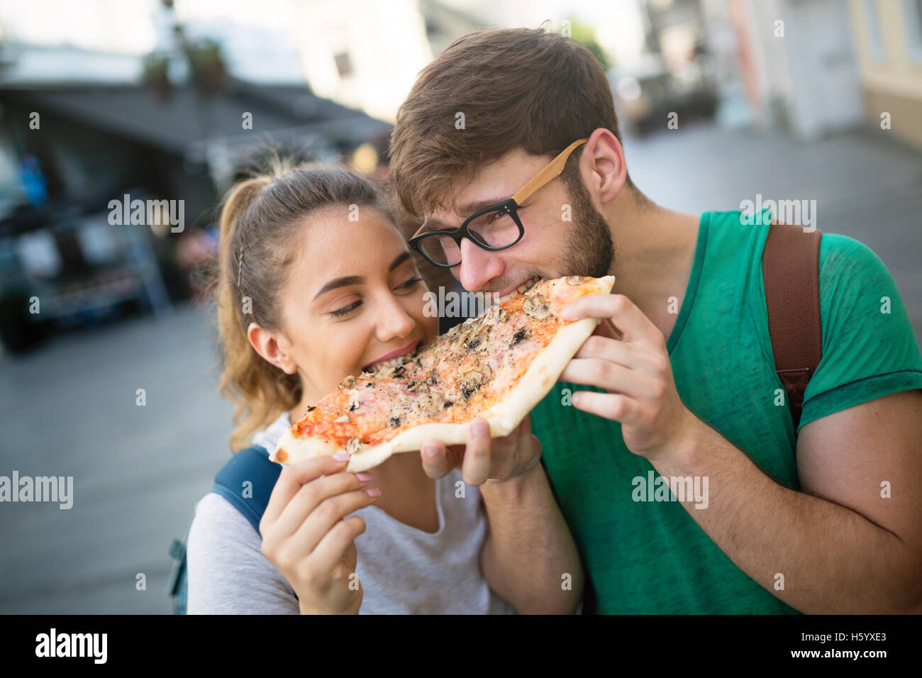 Happy couple eating fast food in city and smiling Stock Photo - Alamy