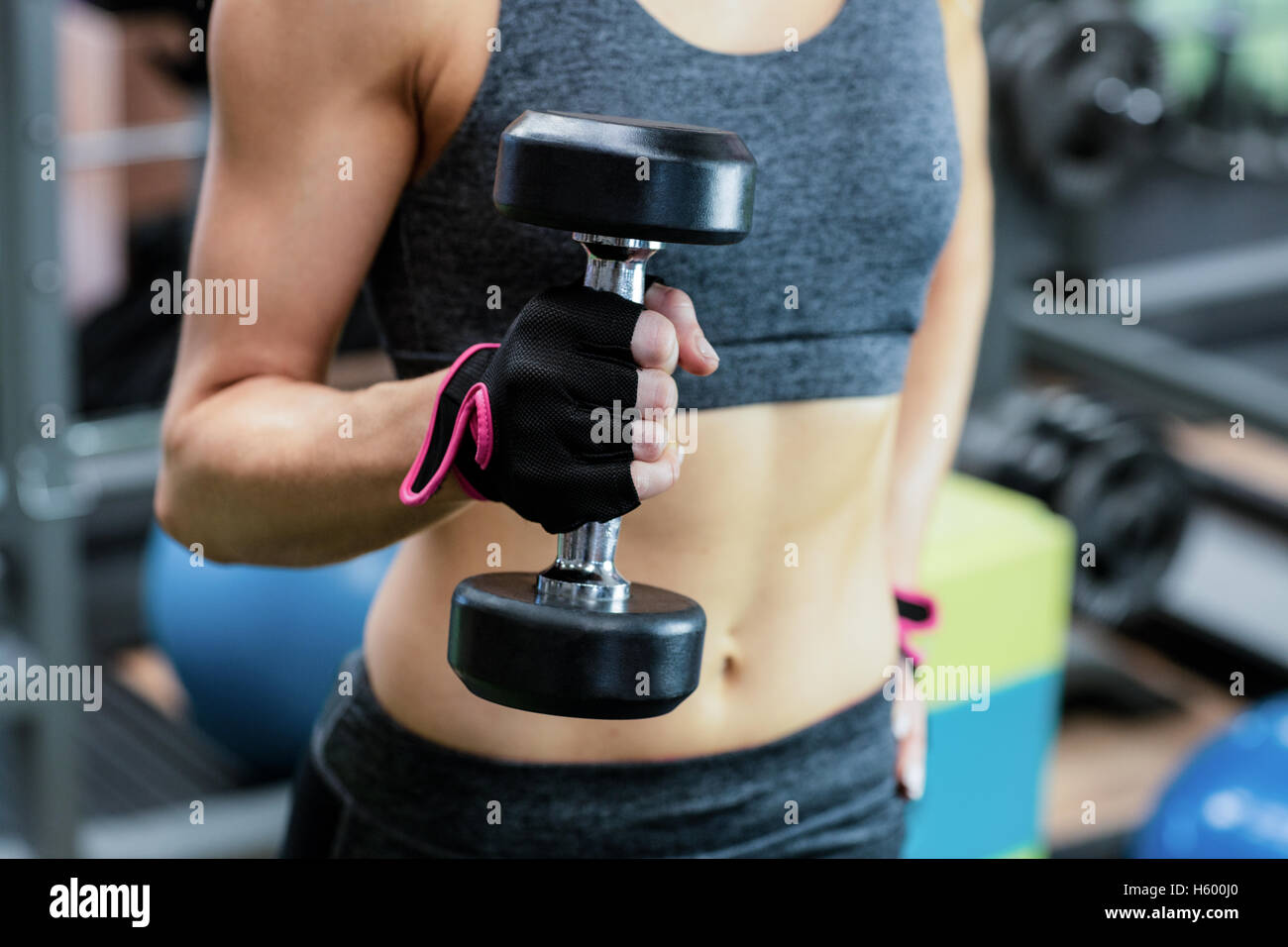 Woman lifting dumbbell Stock Photo - Alamy