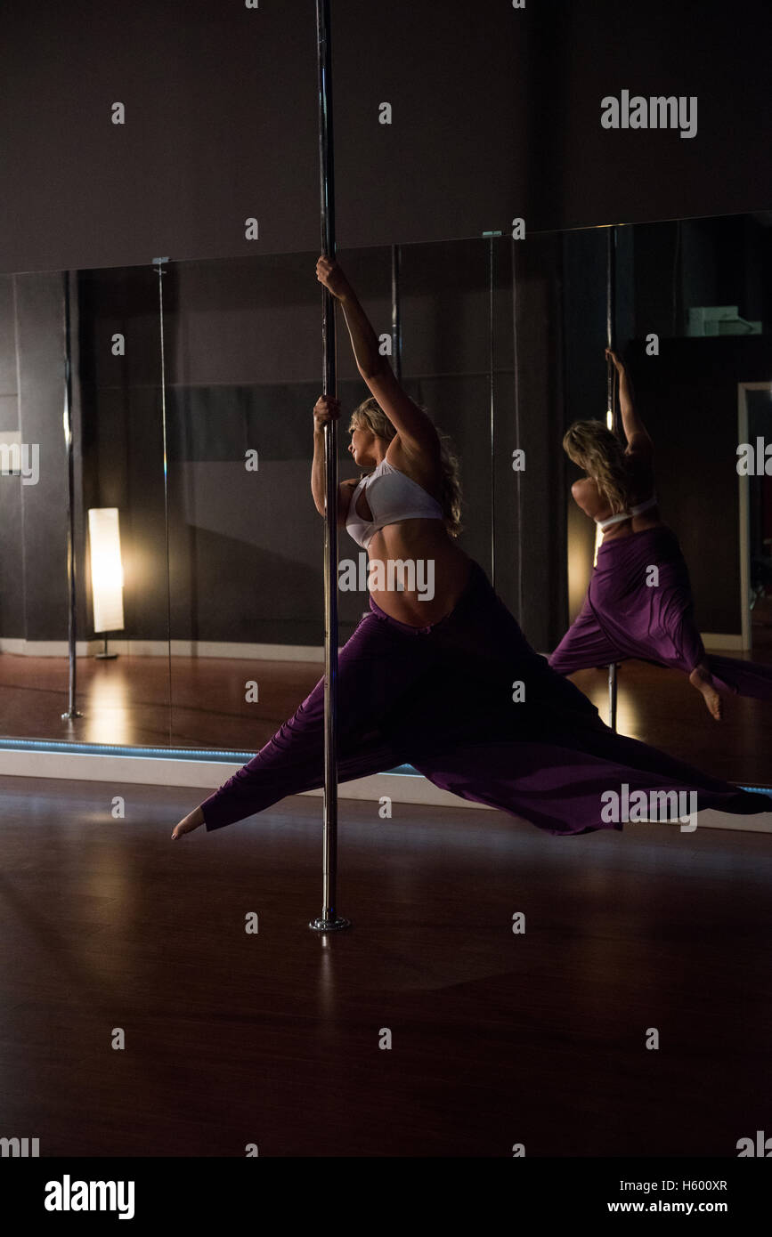 Pole dancer practicing pole dance Stock Photo - Alamy