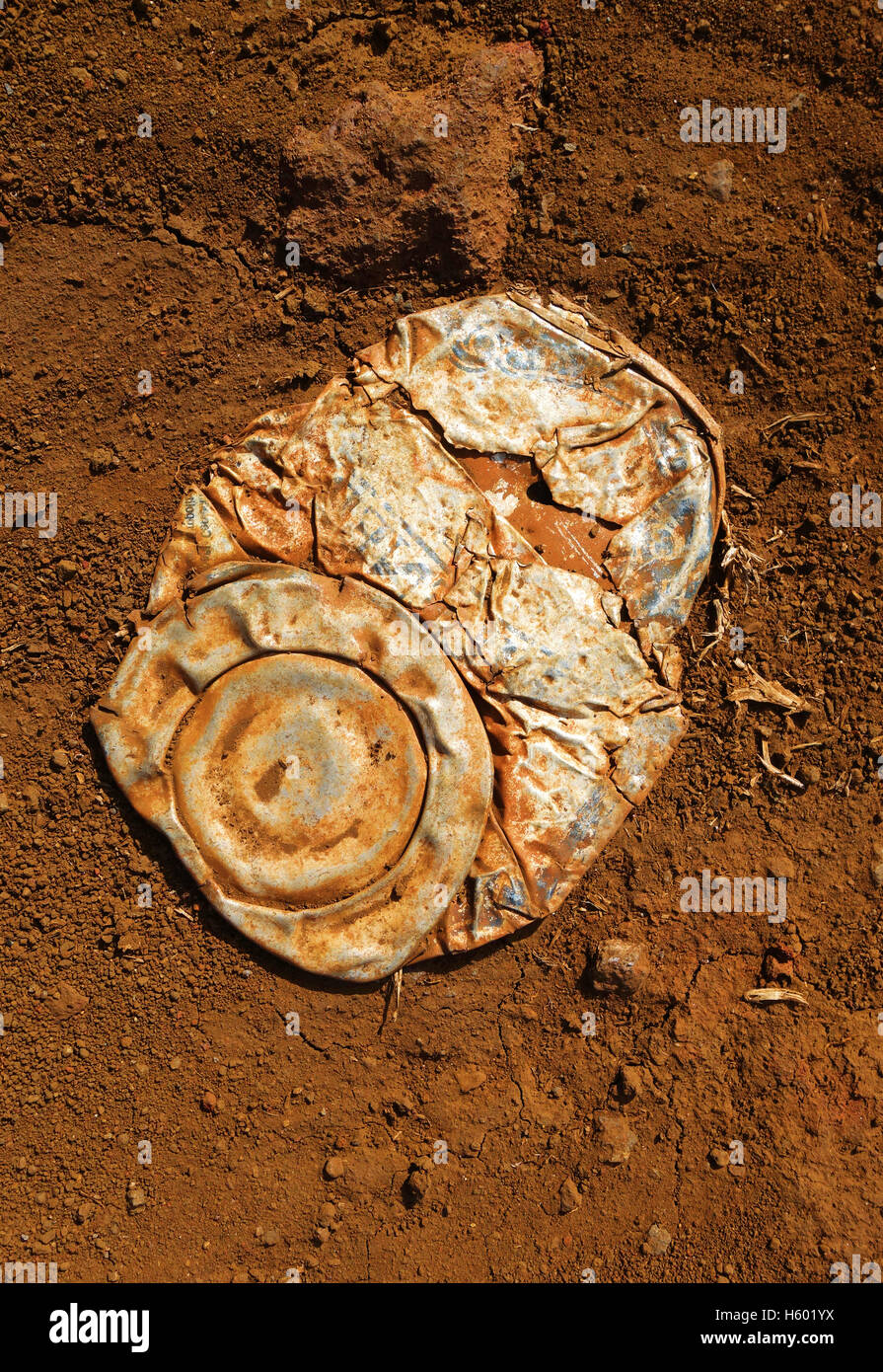 Old crushed rusty tin can on dusty background Stock Photo - Alamy