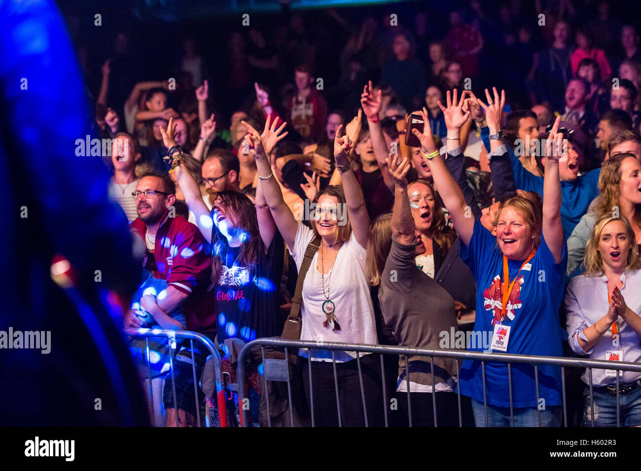 Crowds watch an Oasis tribute band play an atmospheric night time ...