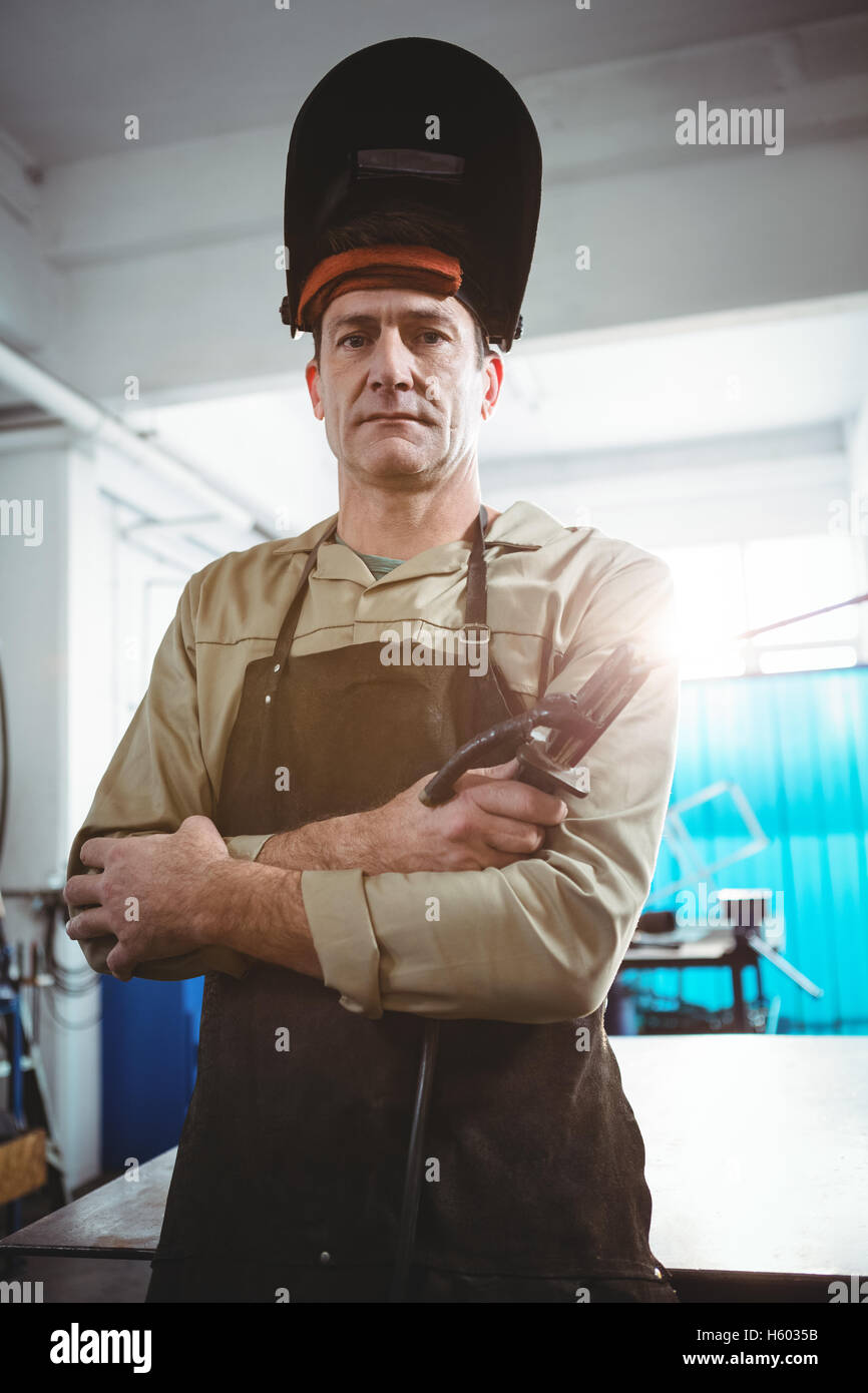 Welder standing with arm crossed in workshop Stock Photo - Alamy