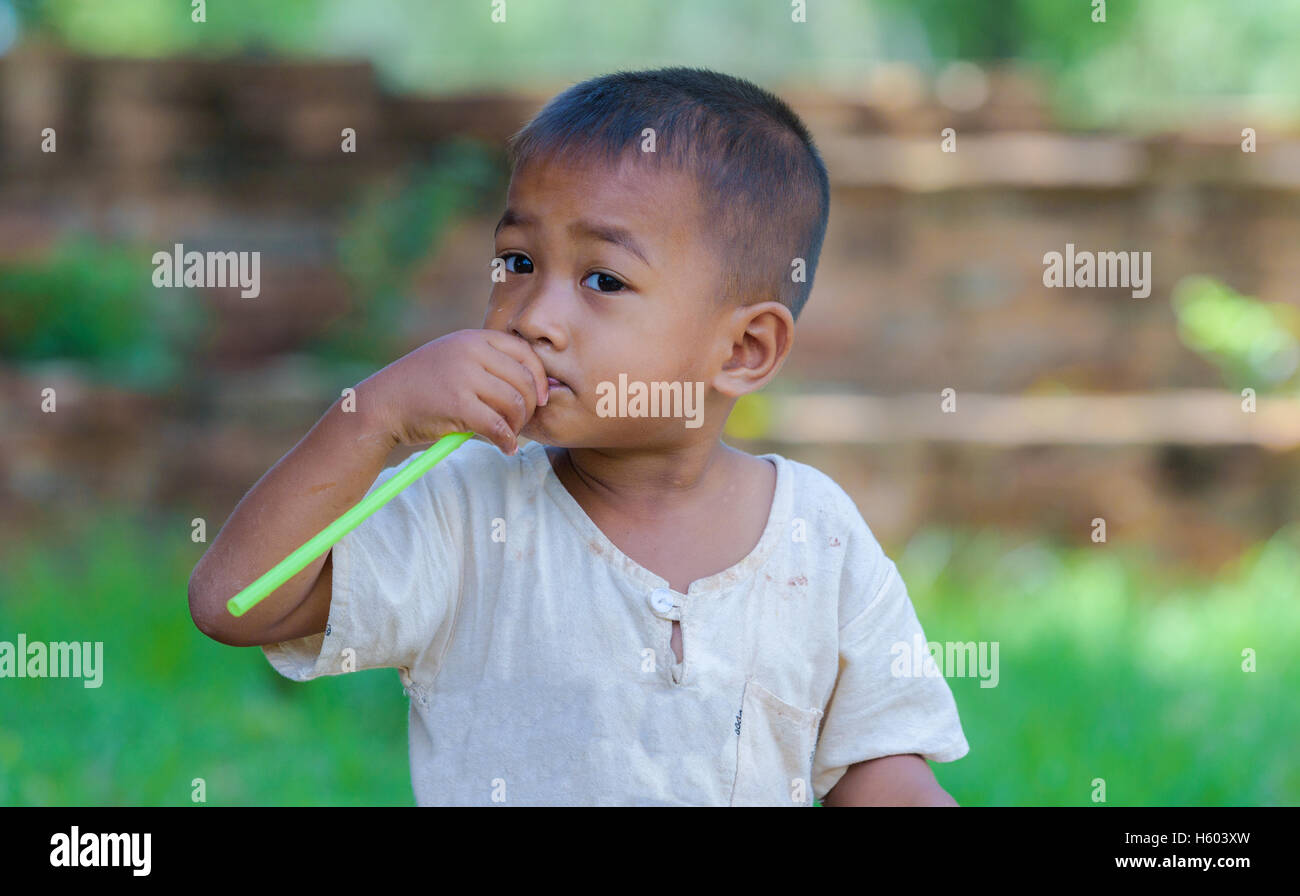 Asian boy with straw in mouth,dirty with innocent play Stock Photo - Alamy