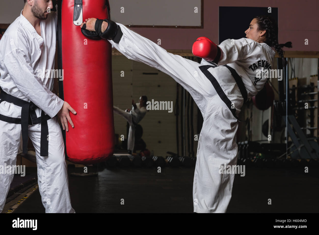 Man and woman practicing karate with punching bag Stock Photo - Alamy
