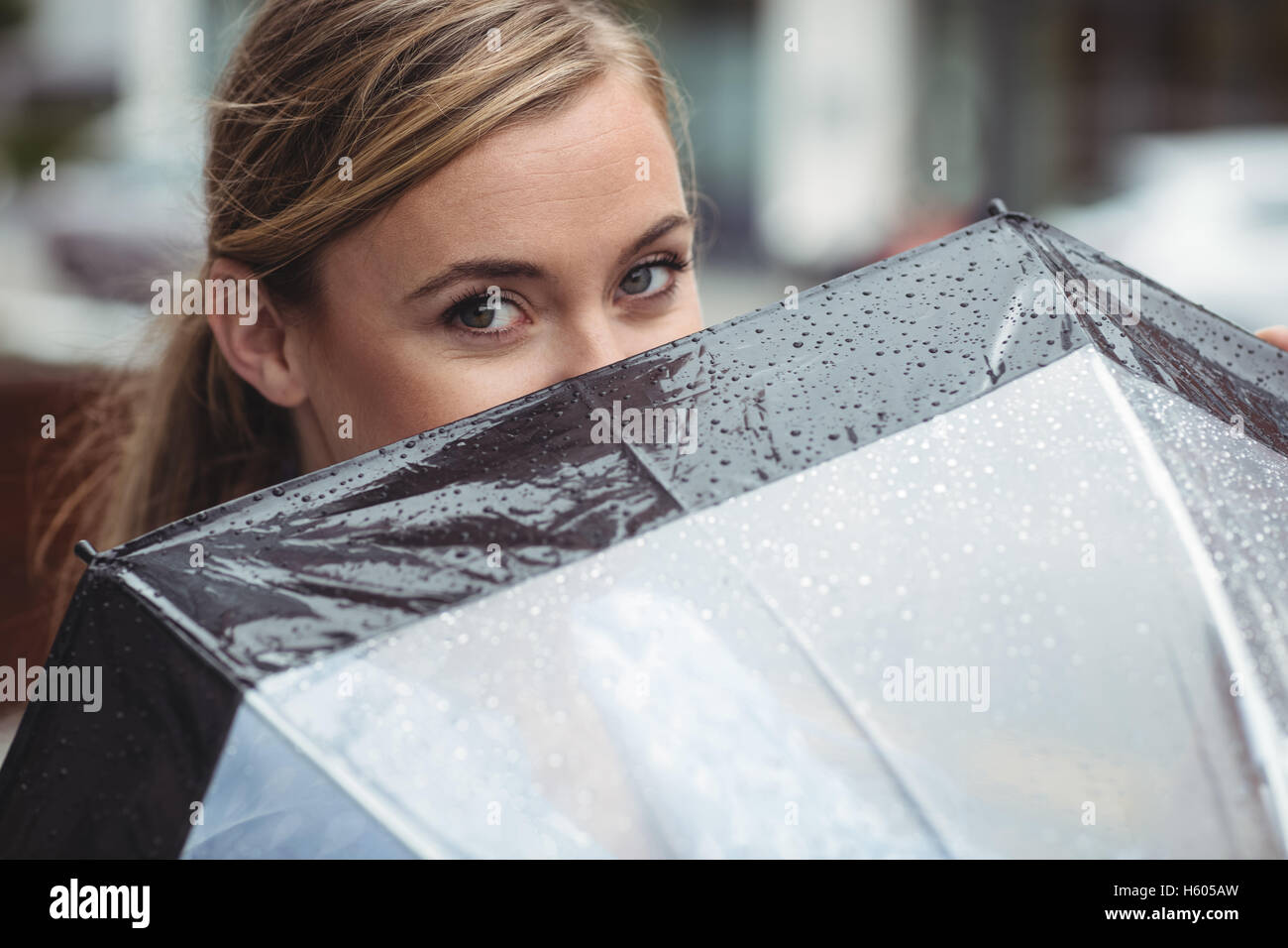 Beautiful woman covering her face with umbrella Stock Photo - Alamy