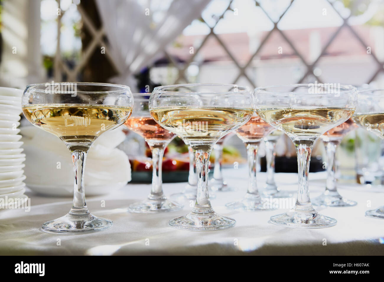 a row of glasses filled with champagne are lined up ready to be served ...