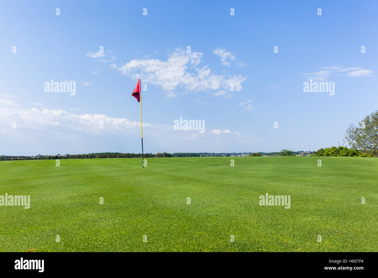 Golf course hole putting green flag stick hole closeup photo blue sky ...