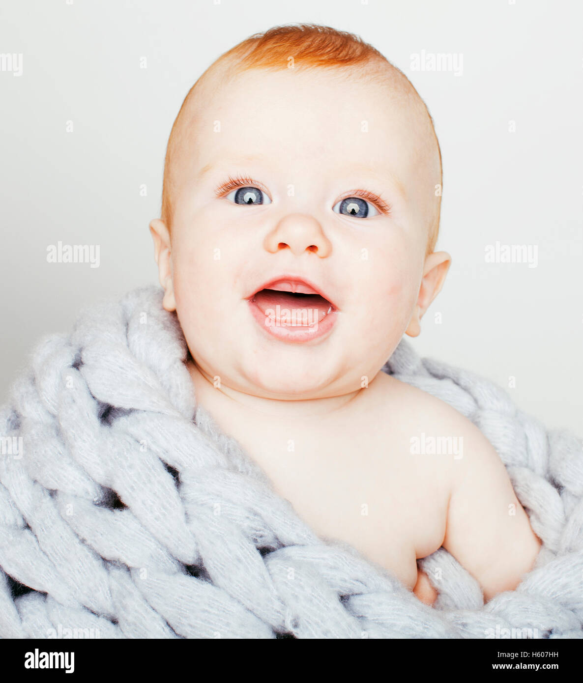 little cute red head baby in scarf all over him close up isolate Stock ...