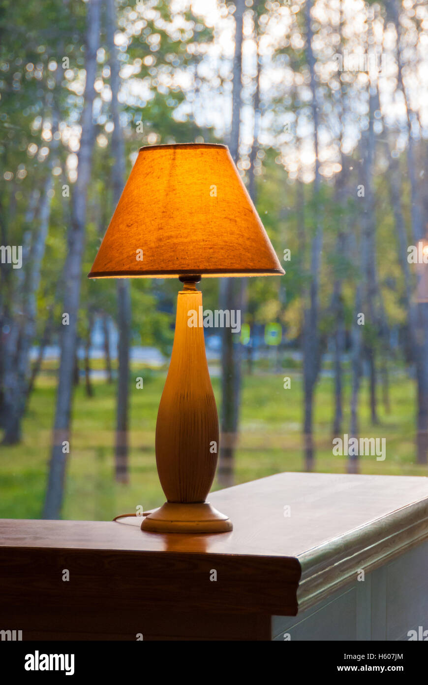 Burning table lamp in front of the window Stock Photo - Alamy