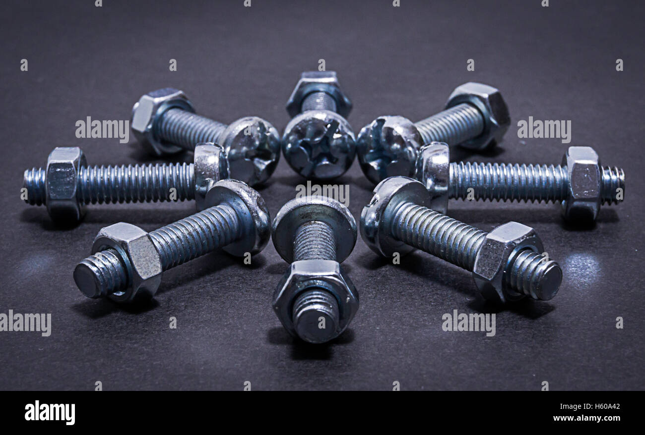 Several screws on black surface Stock Photo - Alamy