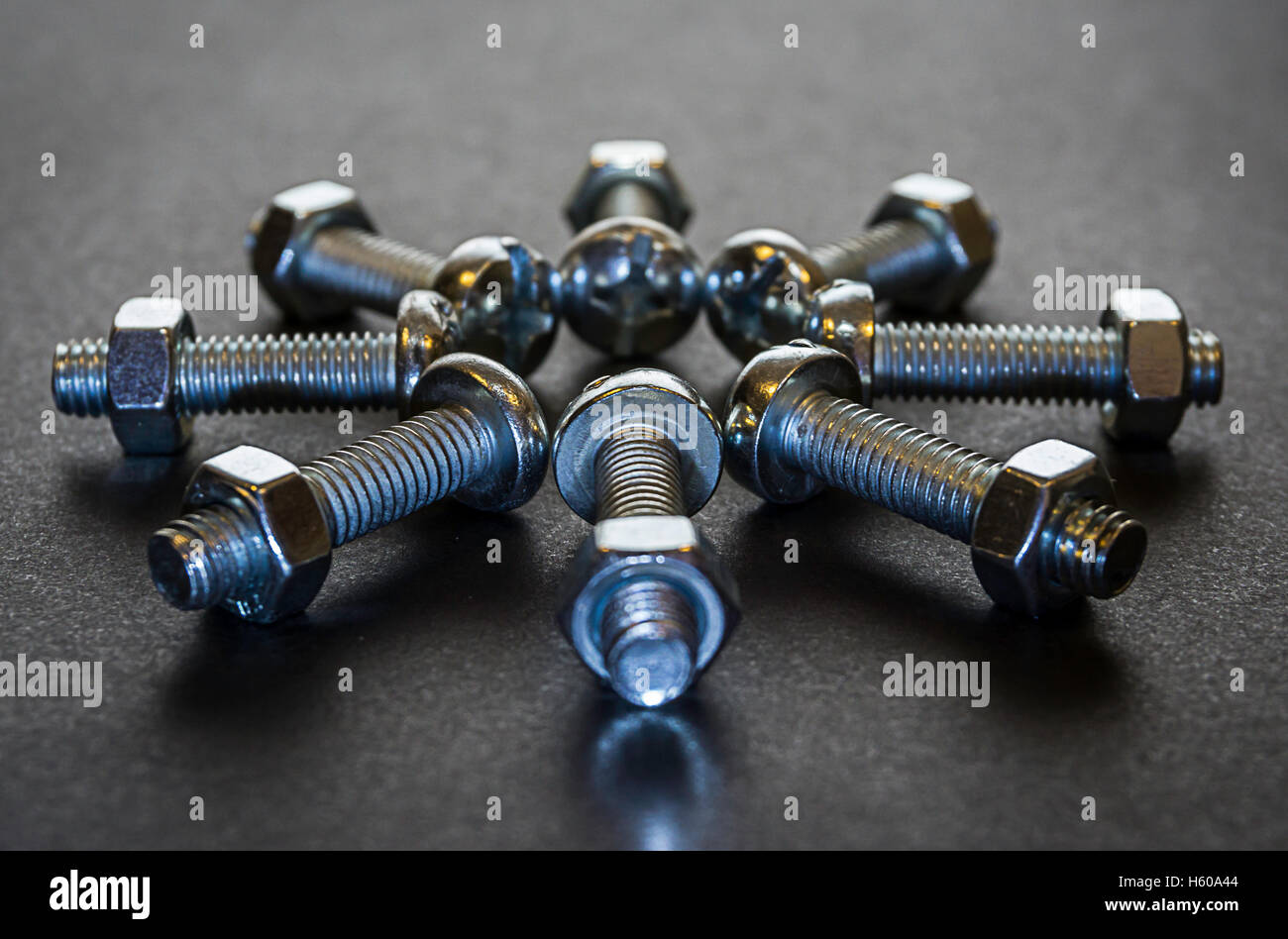 Several screws on black surface Stock Photo - Alamy